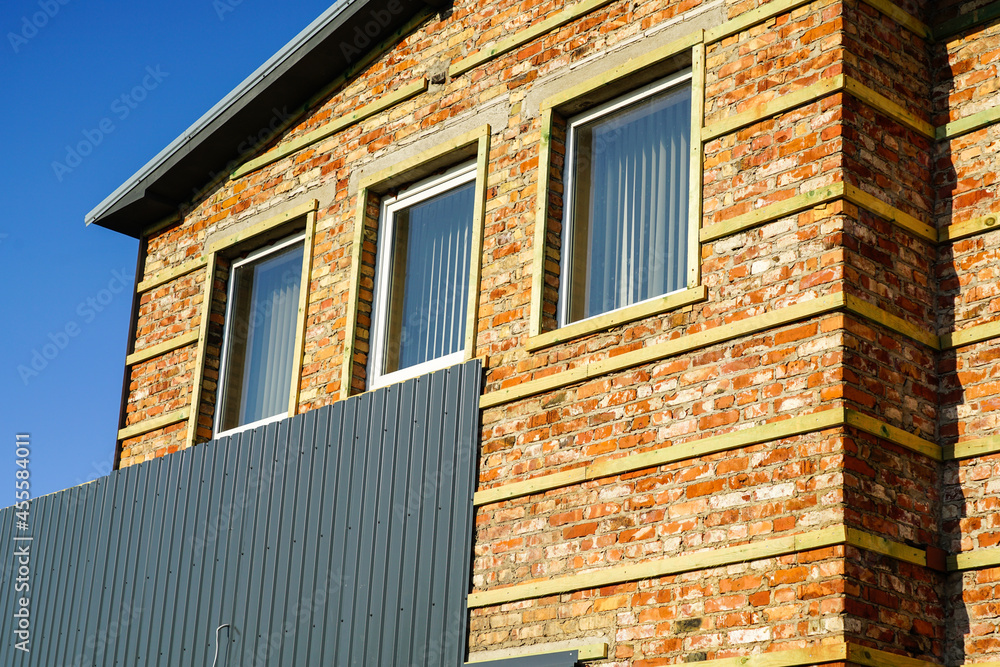 cladding of a brick house facade with corrugated sheet metal Stock ...