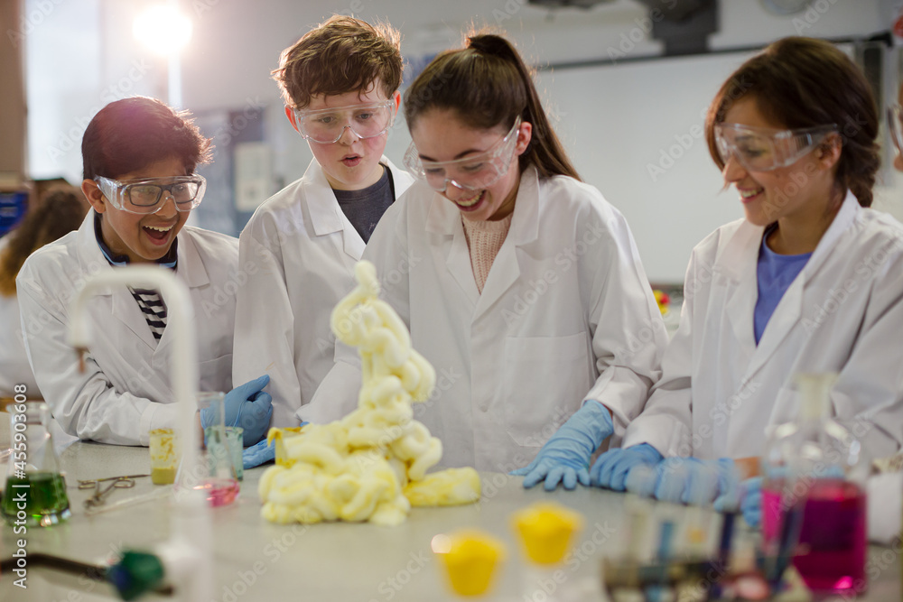 Surprised students conducting exploding foam scientific experiment in ...