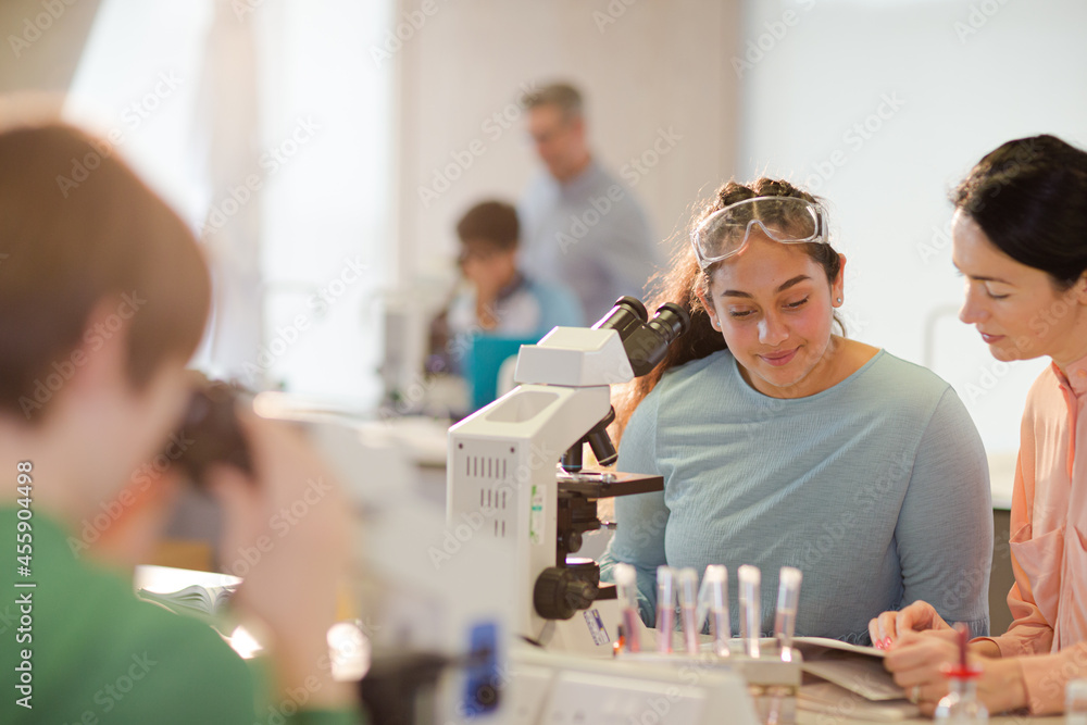 Female teacher and girl student conducting scientific experiment at ...
