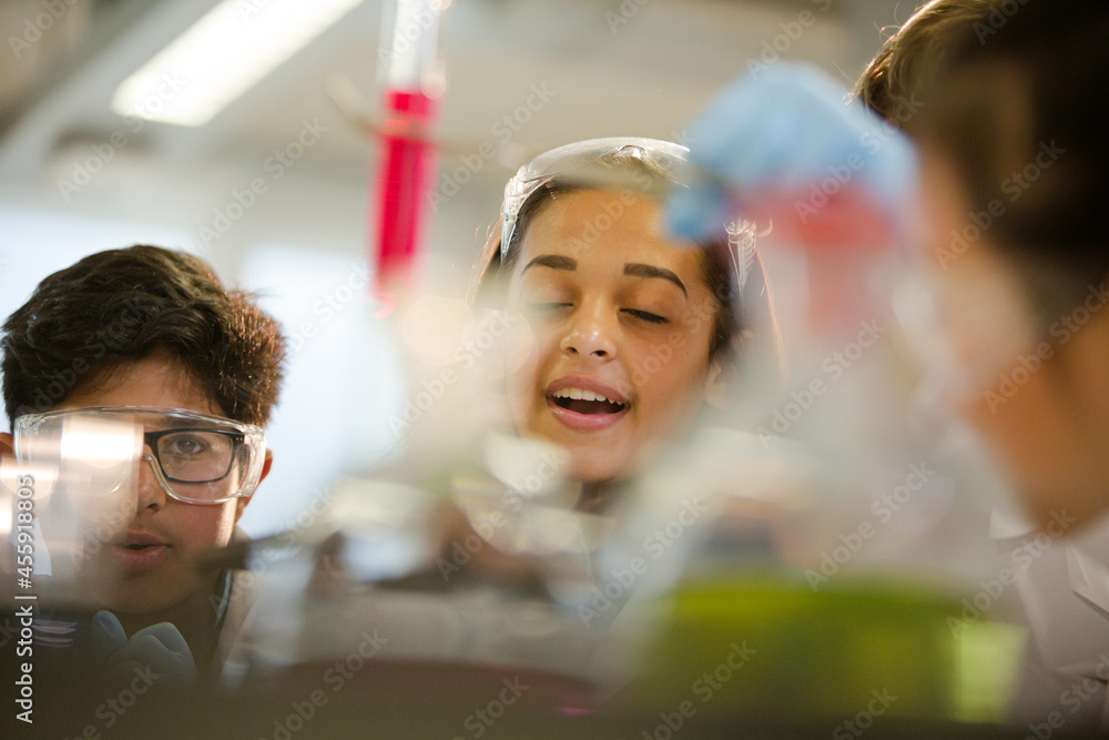 Students examining liquid in test tube, conducting scientific ...