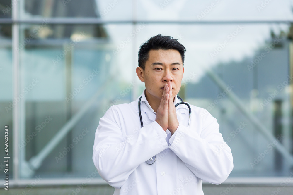 portrait Asian doctor tired after work, puts his hands to his face ...