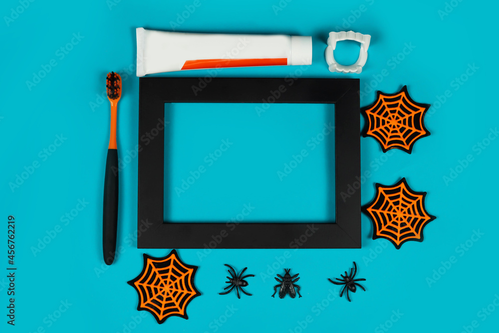 Layout top view of toothpaste, brush, vampire teeth and spider webs in ...