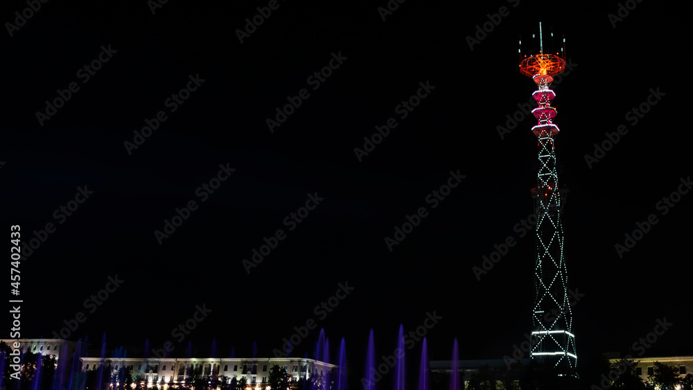 Glowing TV tower at night. Festive illuminated broadcast tower. Space ...