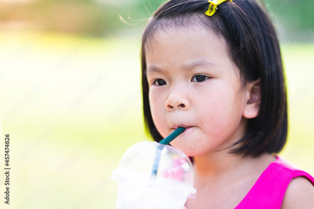 Cute Asian Girl Sucking Water From A Plastic Glass With A Green Straw 2801