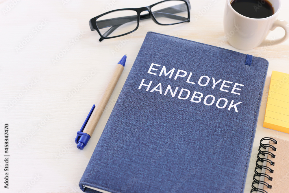 Concept image of employee handbook over wooden office table. top view ...