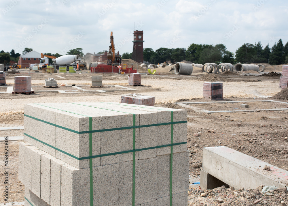 Concrete blocks and bricks on new housing development construction site and next to house ...