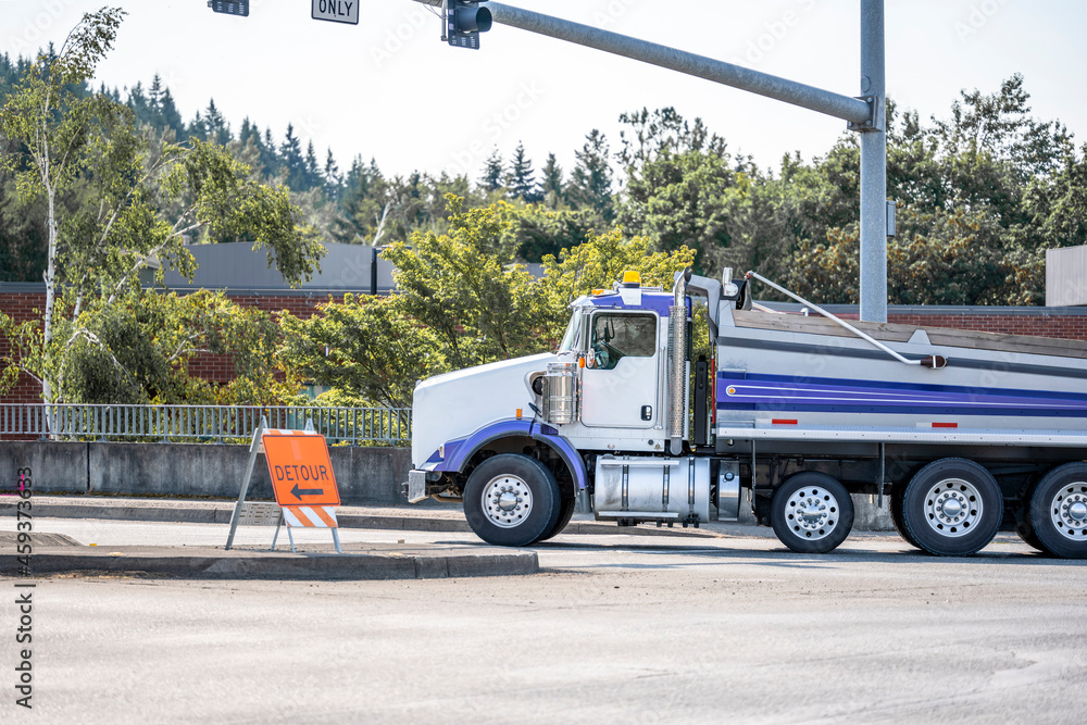 Powerful tip truck with covered trailer running on the city street ...