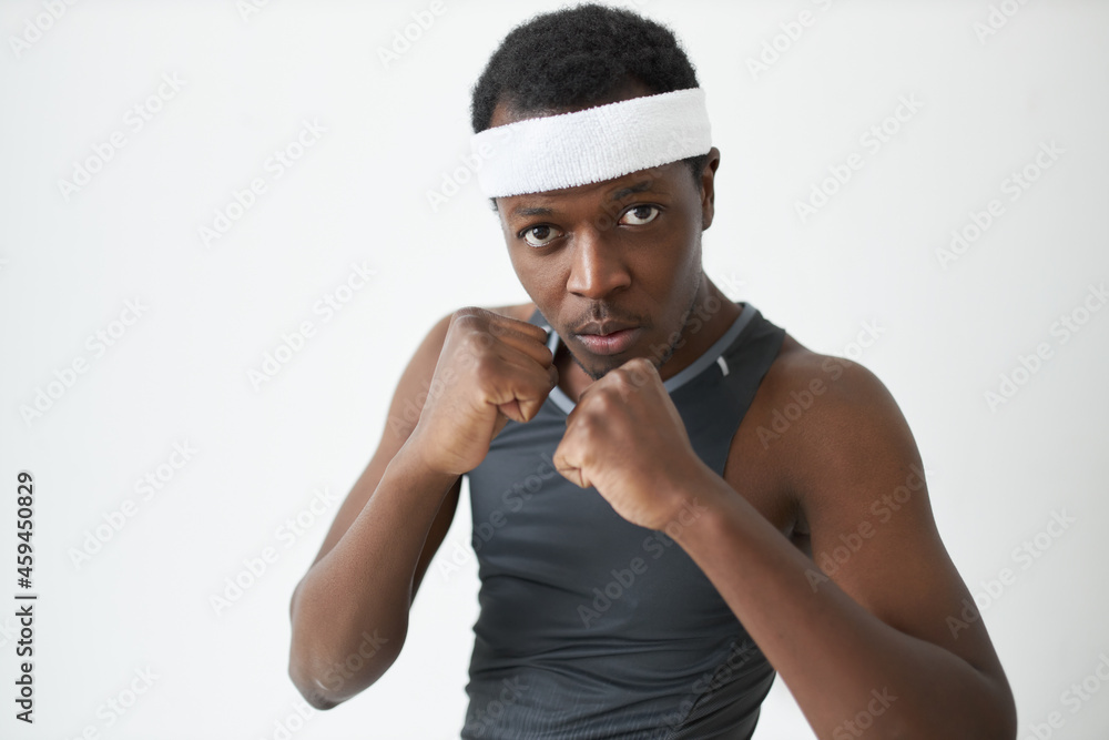 Studio image of dark-skinned athlete holding fists in front of him in ...