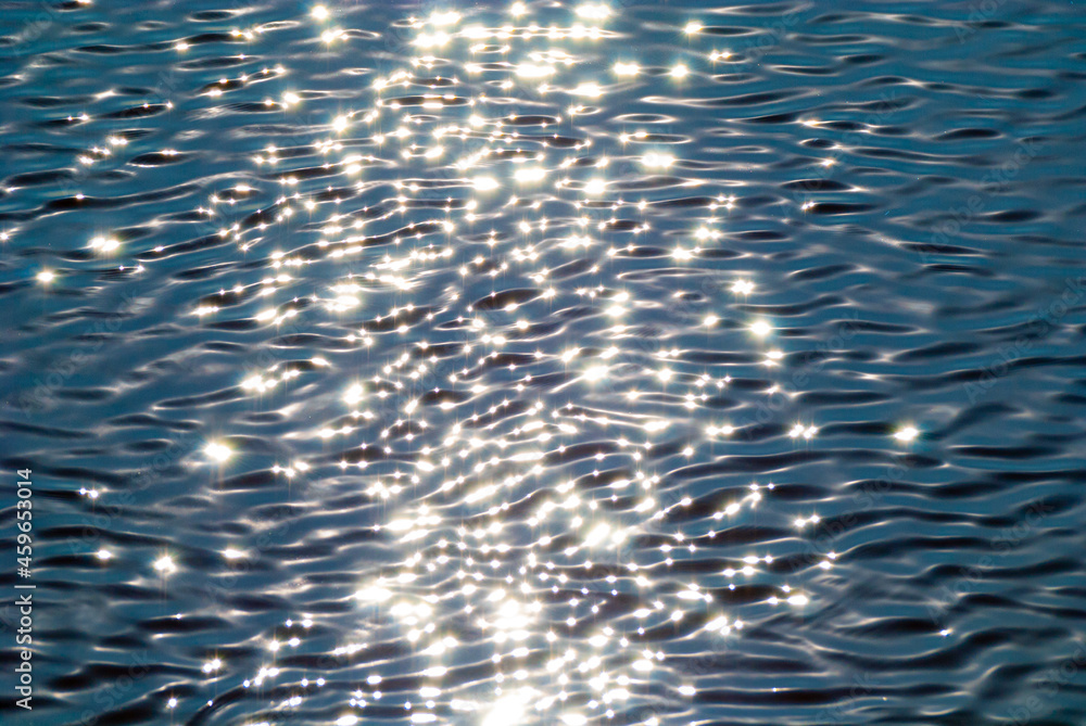 light solid ripples on the sea water of pale blue color with glare from ...