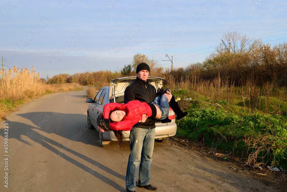 The guy puts corpse of the girl in the trunk of a car Stock Photo ...