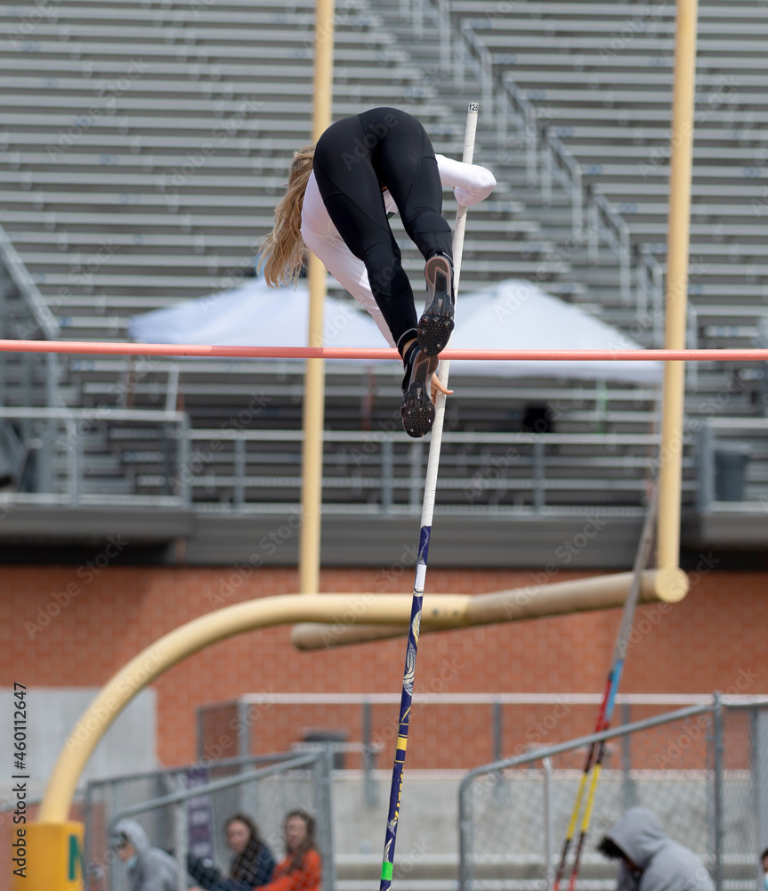 High School girls competing in pole vault at a track and field meet ...