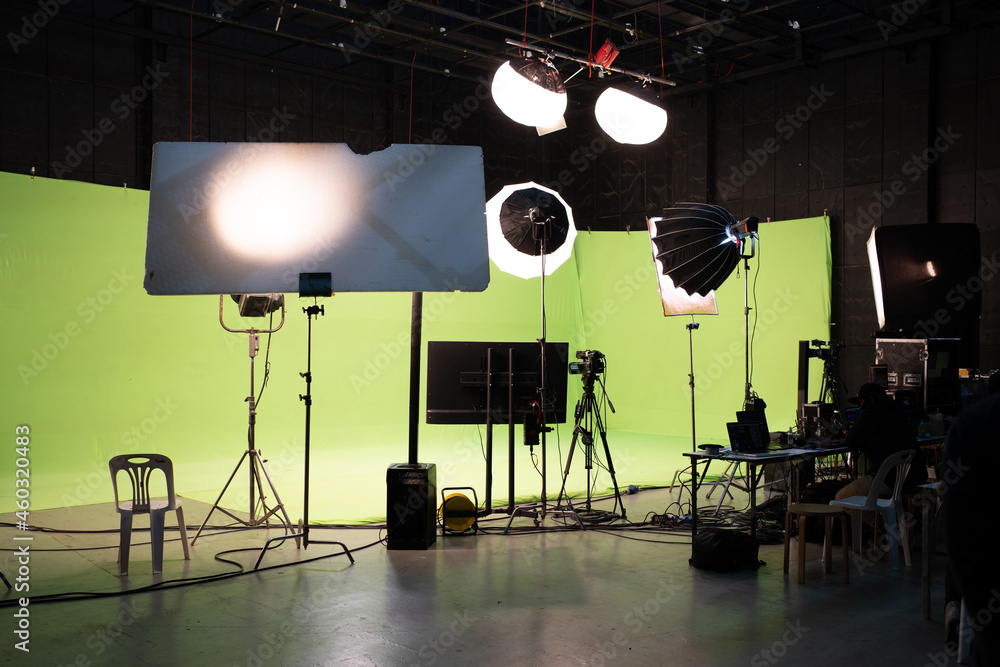 Behind the scenes of a green screen set with a video camera, monitor ...