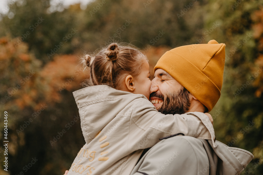Happy father and daughter playing while walking in a beautiful autumn ...