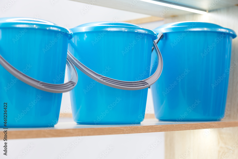 Three new plastic blue utility buckets with lid on the shelf ...