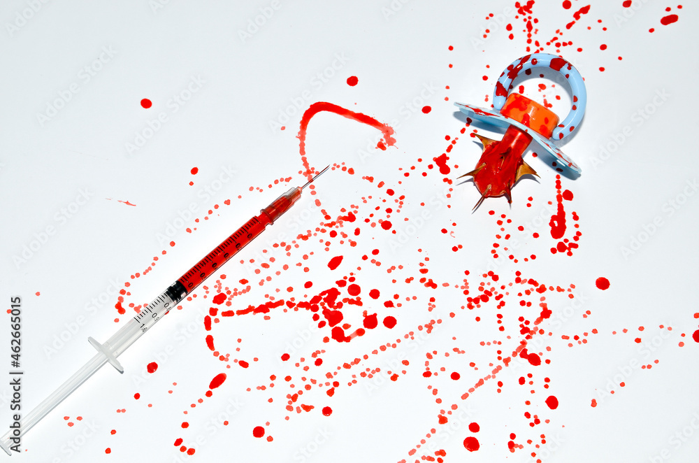 Baby's dummy with Drops of blood staining spots on a white background ...
