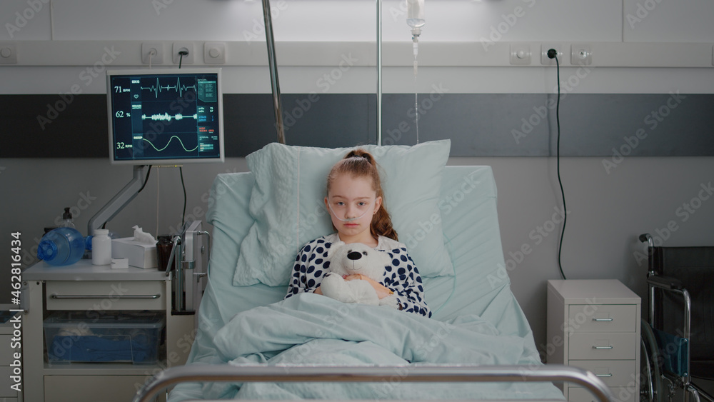 Portrait of hospitalized sick girl child patient holding teddy bear ...
