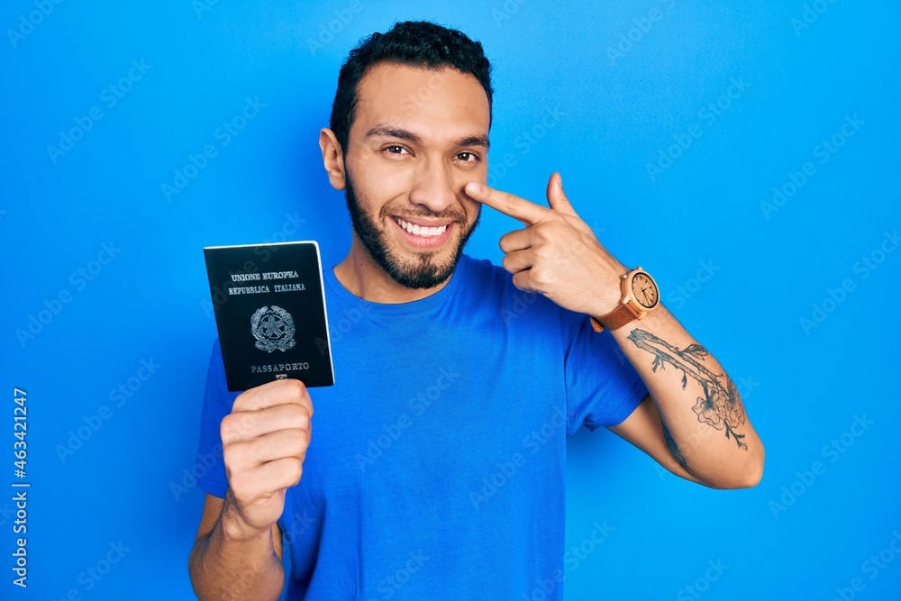 Hispanic man with beard holding italy passport pointing with hand ...