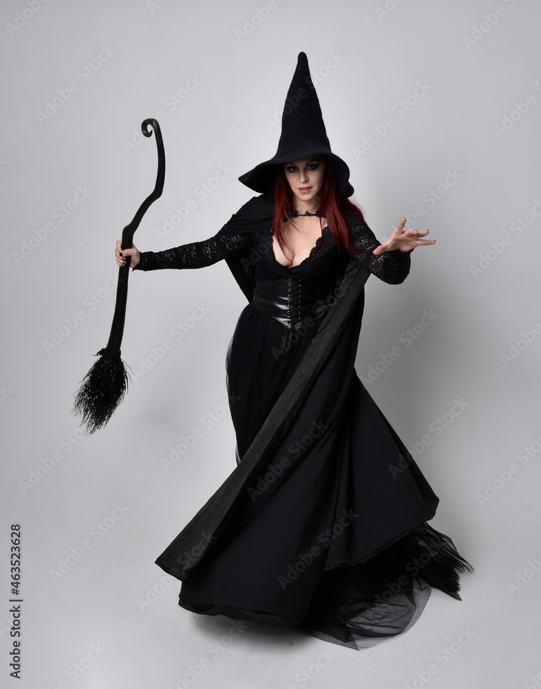 Full length portrait of dark haired woman wearing black victorian witch ...