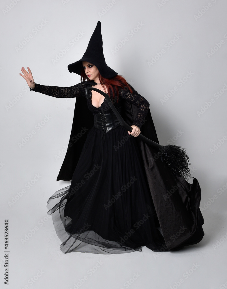 Full length portrait of dark haired woman wearing black victorian witch ...