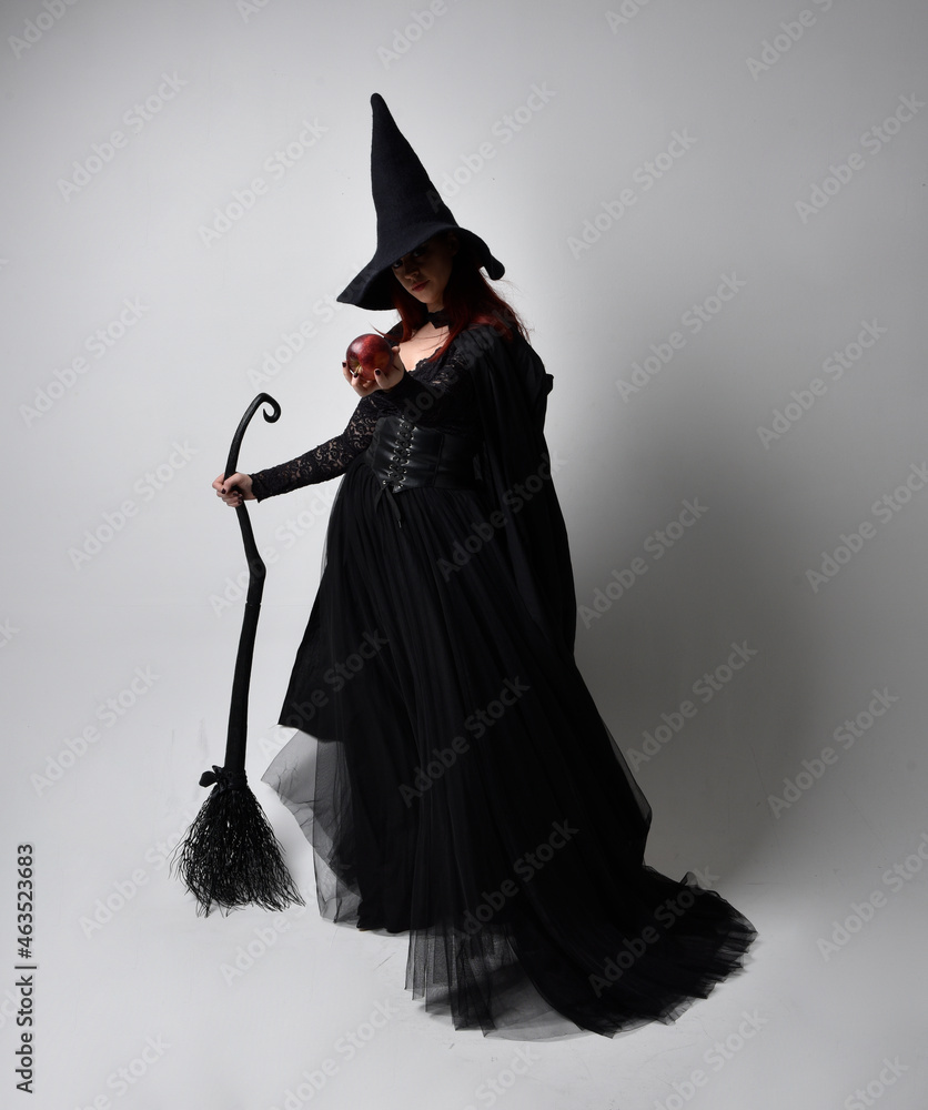 Full length portrait of dark haired woman wearing black victorian witch ...
