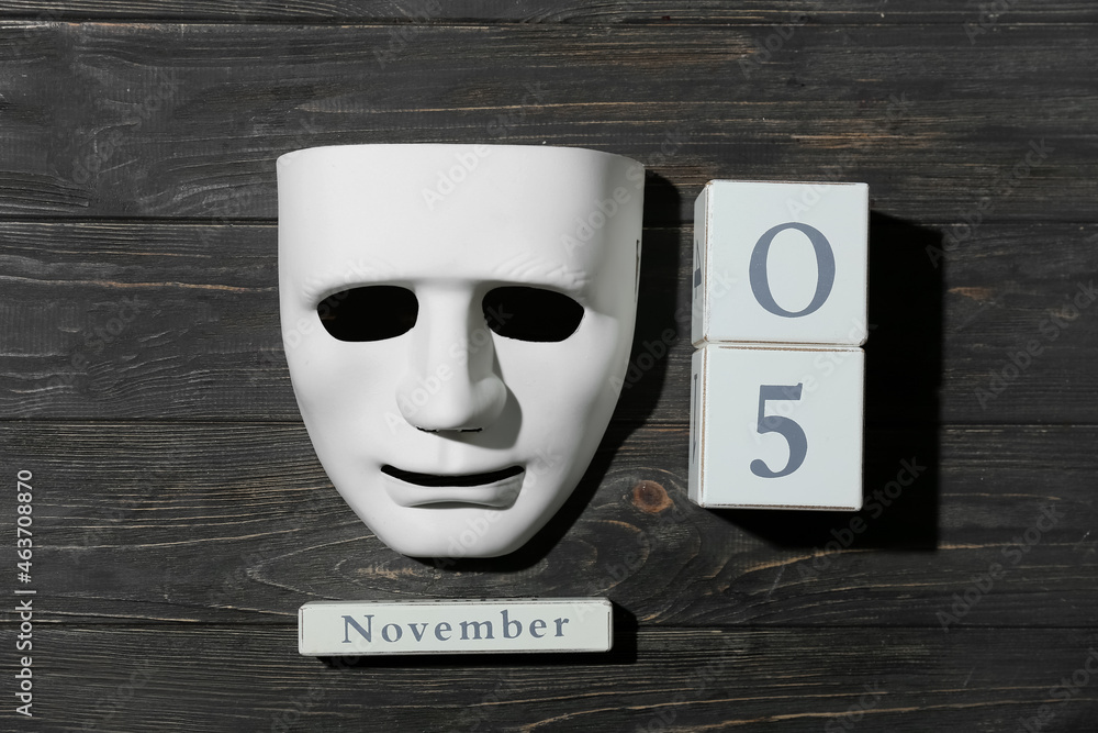 Guy Fawkes mask and calendar with date of November 5 on dark wooden ...