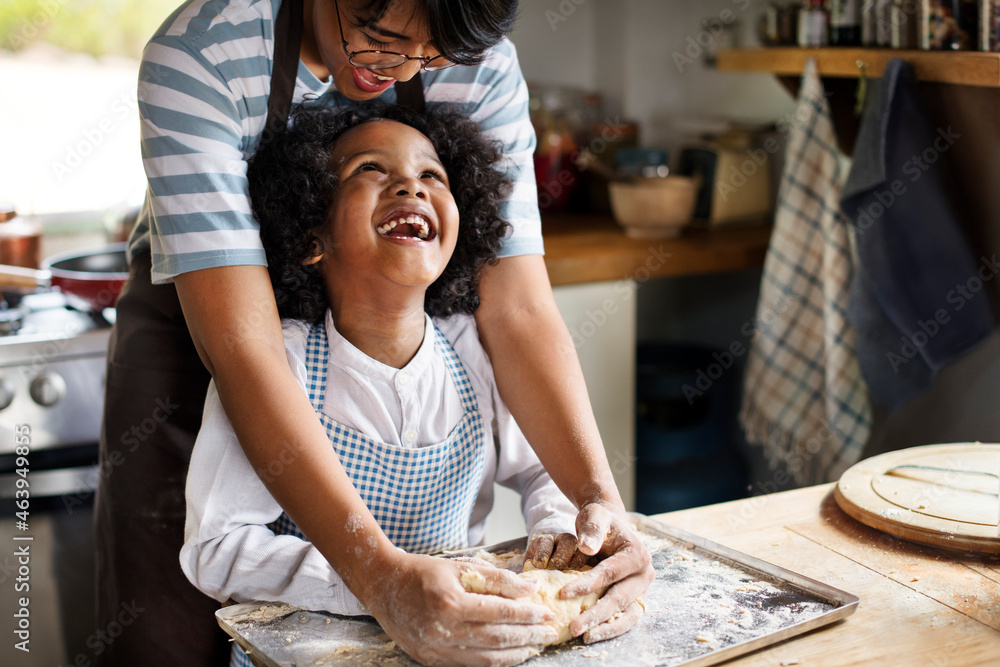 Young boy learning to bake with his mother Stock Photo | Adobe Stock