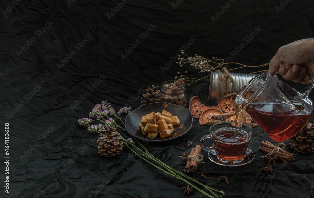 Bael fruit tea is poured from a kettle into glass cup with bark of bael ...