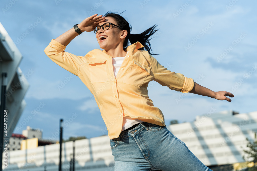 Curious brunette woman looking far away with hand over head, trying to ...