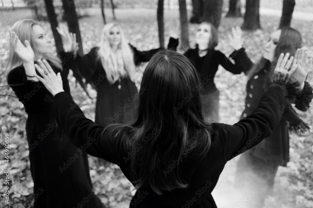 Coven of witches, a group of friends as witches on Halloween perform a ...