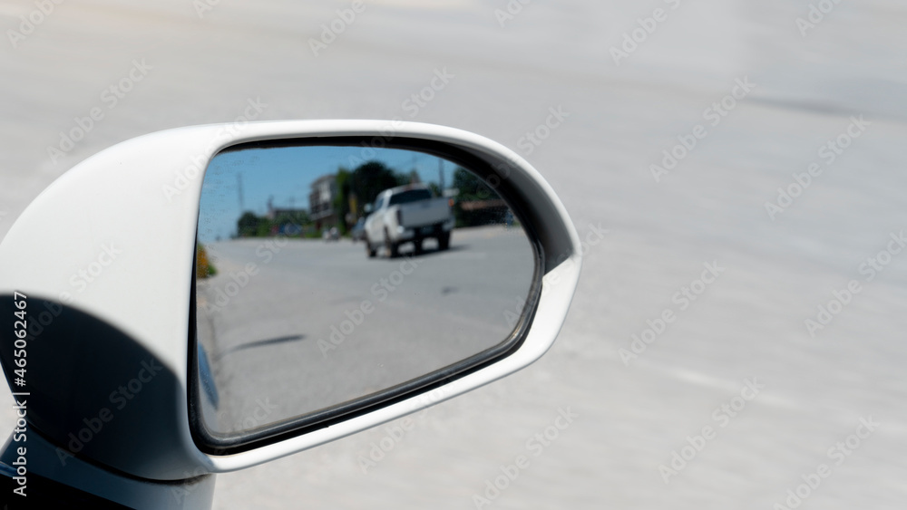 Traffic from behind through the mirrors wing of a white car. with ...