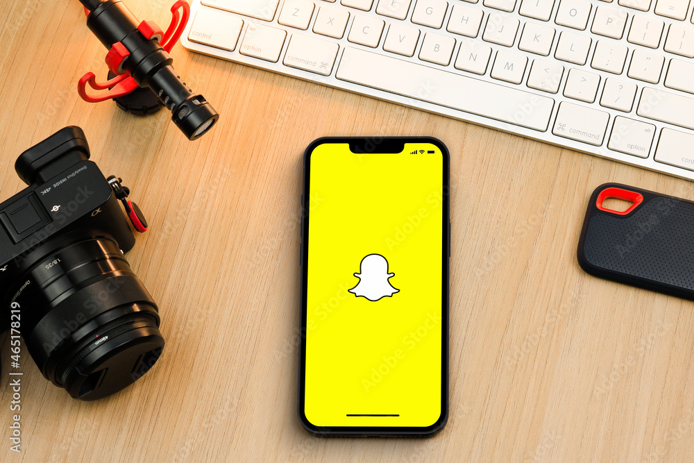 Snapchat app on smartphone iPhone 13 Pro screen on wooden table ...