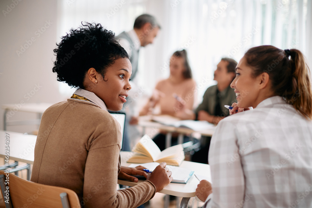 Happy female students talk while studying together at lecture hall ...