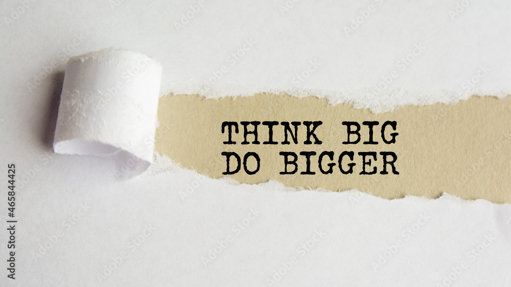 think big do bigger. words. text on grey paper on torn paper background ...