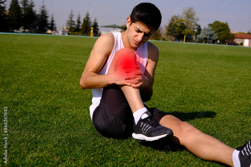 the athlete injured in his leg during sports, is lying on the ground ...