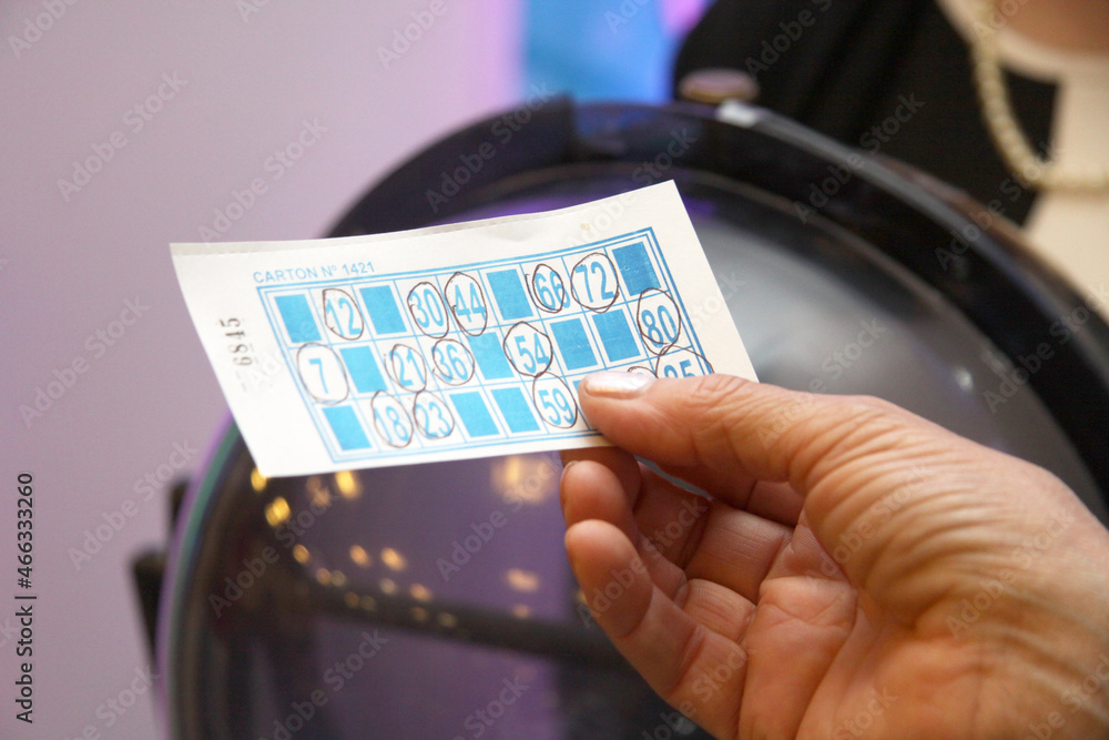 Person playing Bingo. Woman's hands holding cardboard from bingo game ...