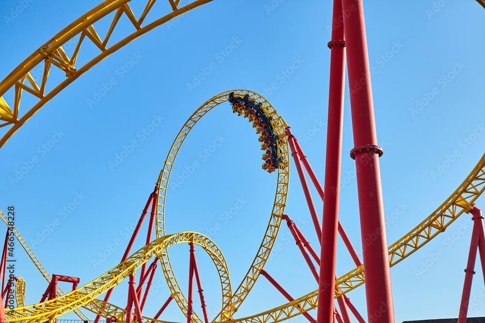 Roller coaster in an amusement park against the blue sky. The concept ...
