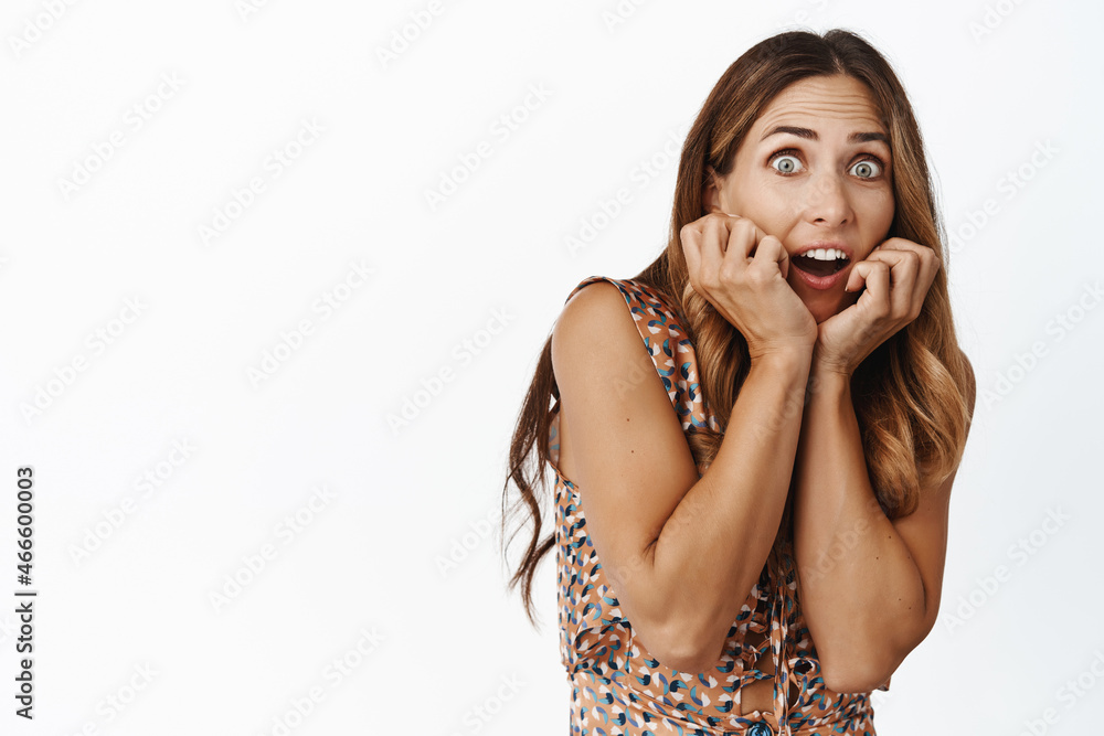 Portrait of middle aged woman screaming in fear, jumping scared of ...