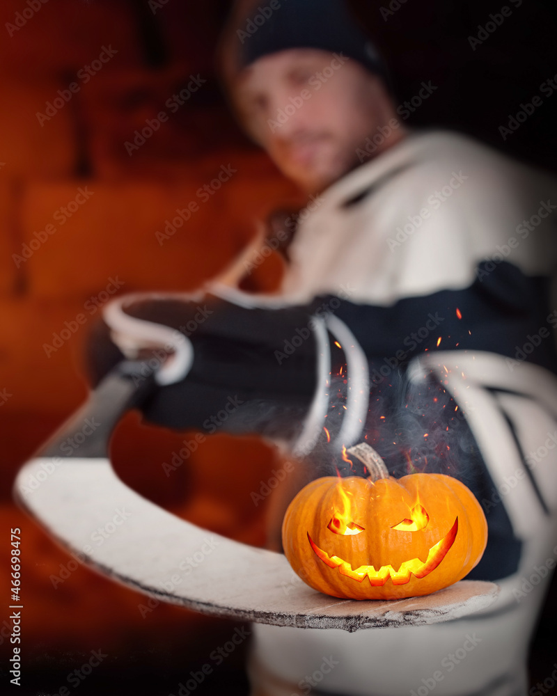 Pumpkin with a spiteful grin and glowing eyes on the hook of a hockey ...
