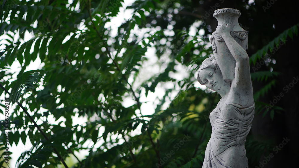 Foto sculpture of a girl in the spring park. An old statue in a park of ...