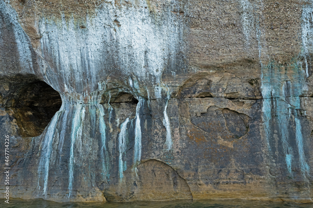 Abstract landscape of a mineral stained cliff along the eroded ...