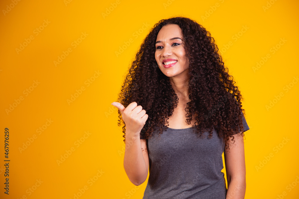 Beautiful young African American woman with curly hair making a happy ...
