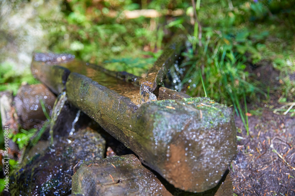 Rustikaler Holzbrunnen im Wald in den österreichischen Alpen. Stock ...