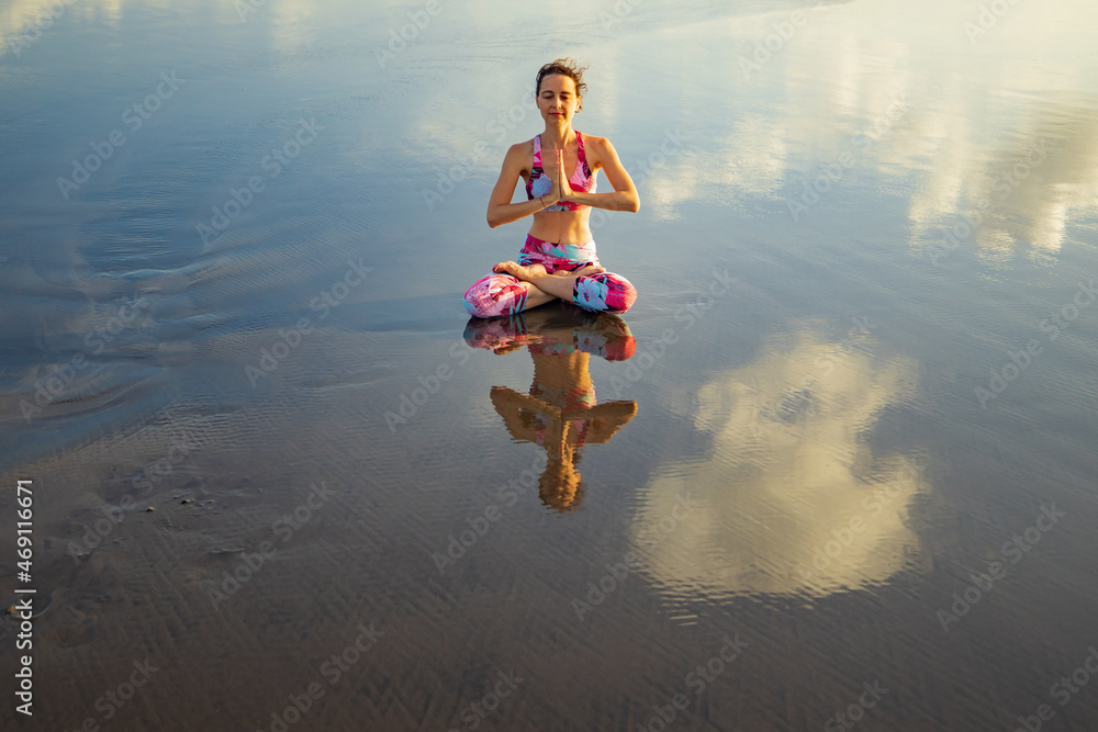 Beach yoga. Lotus pose. Padmasana. Hands in namaste mudra. Closed eyes ...