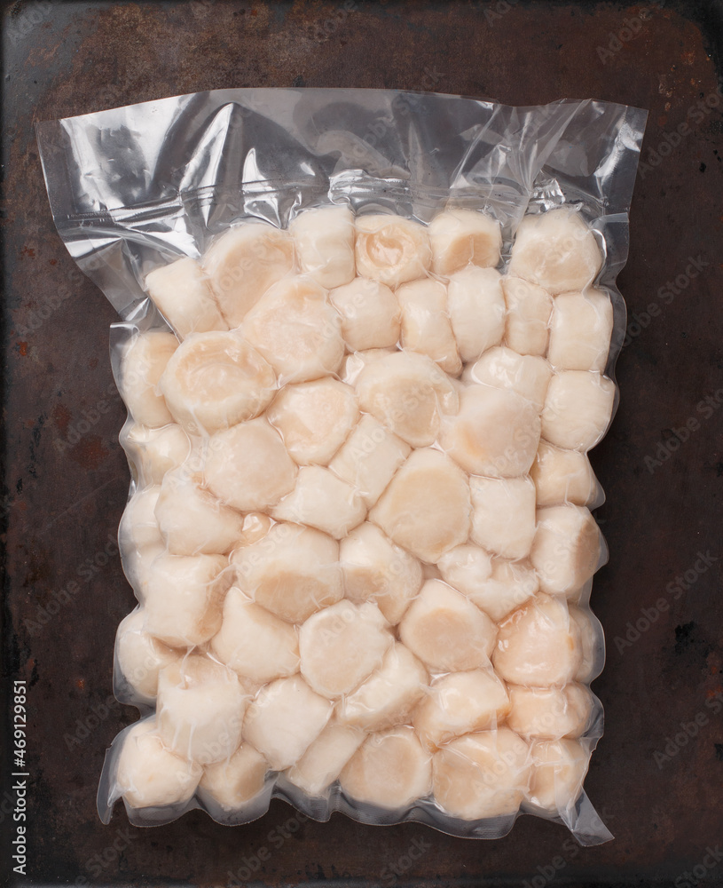 Frozen meat scallop in vacuum package. Raw delicatessen seafood. dark ...