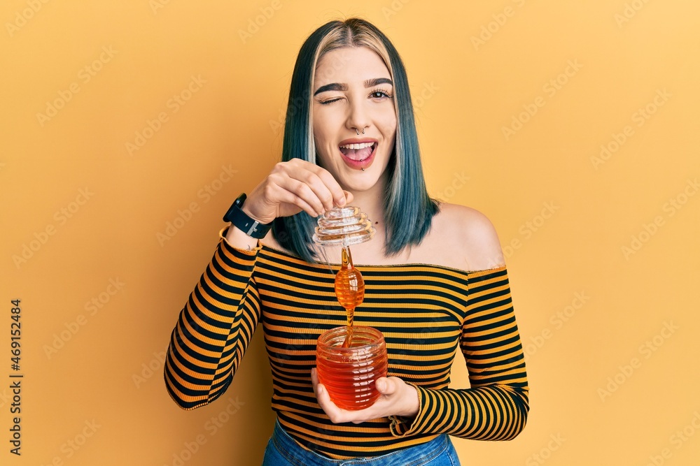 Young modern girl holding honey winking looking at the camera with sexy ...