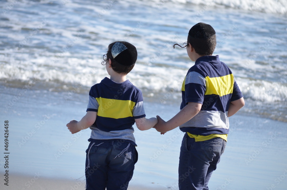 Foto jewish children brothers playing on the beach, holding hands ...