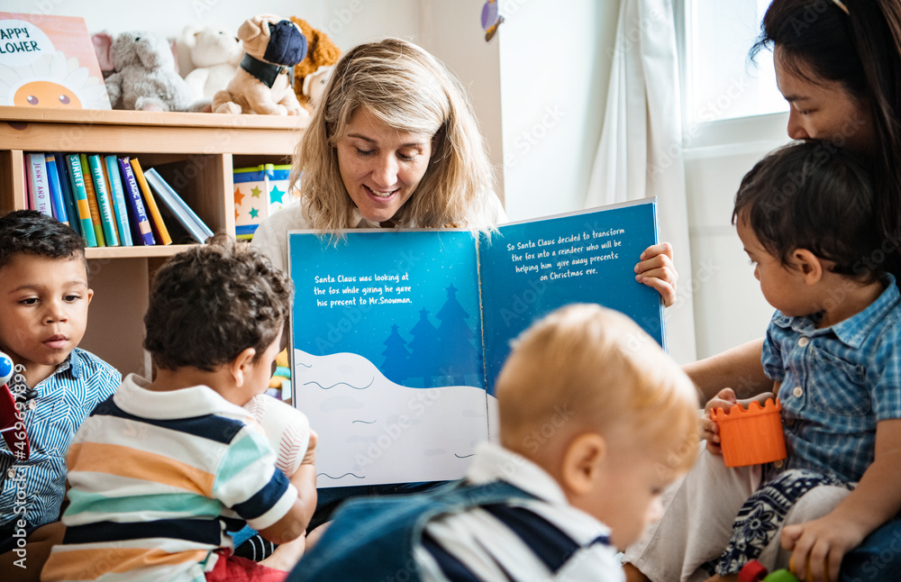 Teacher and students reading a Christmas story together Stock Photo ...