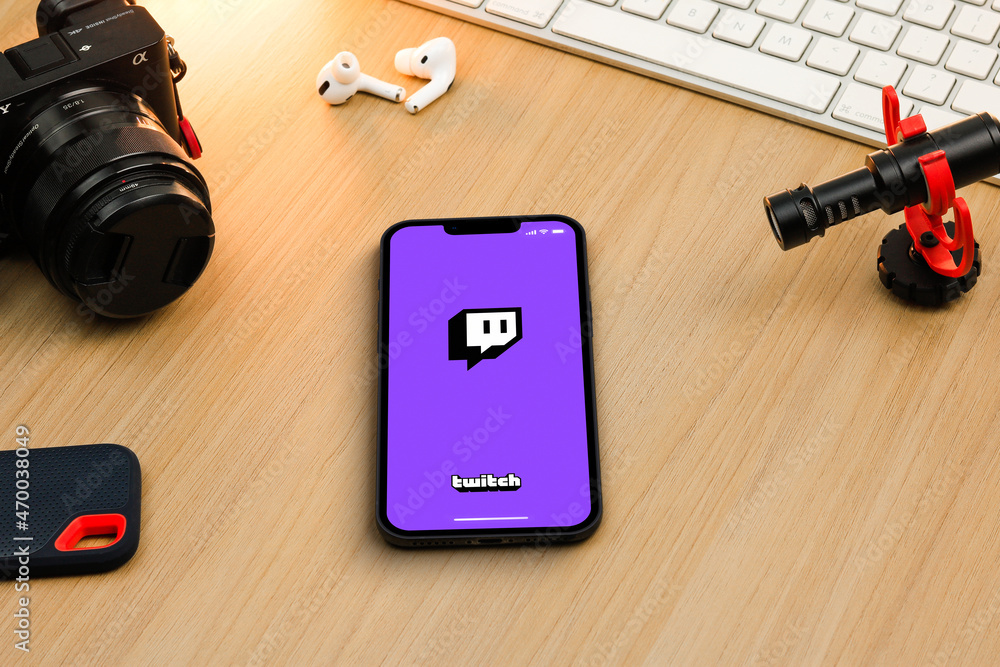 Twitch app on smartphone iPhone 13 Pro screen on wooden table. Content ...