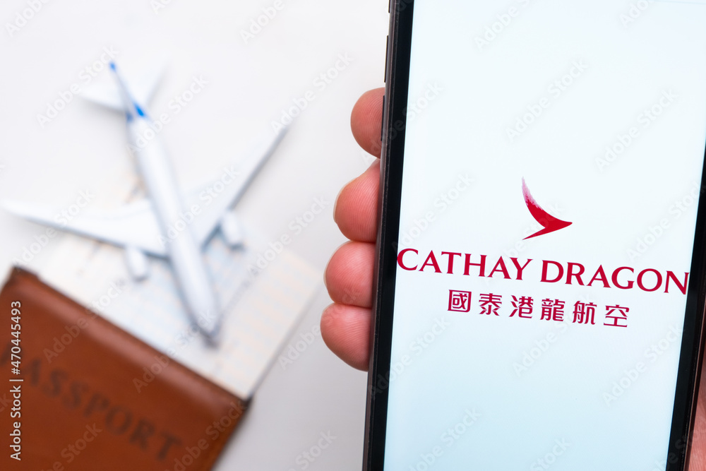 Cathay Dragon Airlines app logo on the screen of mobile phone. A blurry ...