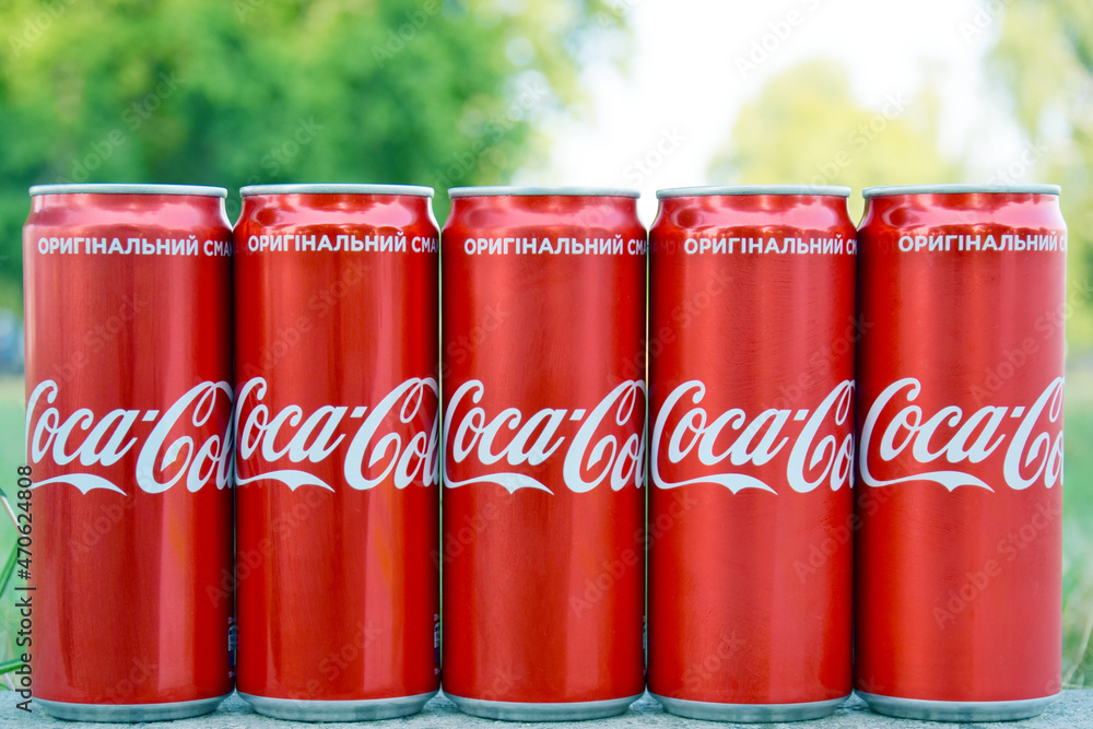 Many cans of Coca-Cola soda with background blurring in a park. Stock ...
